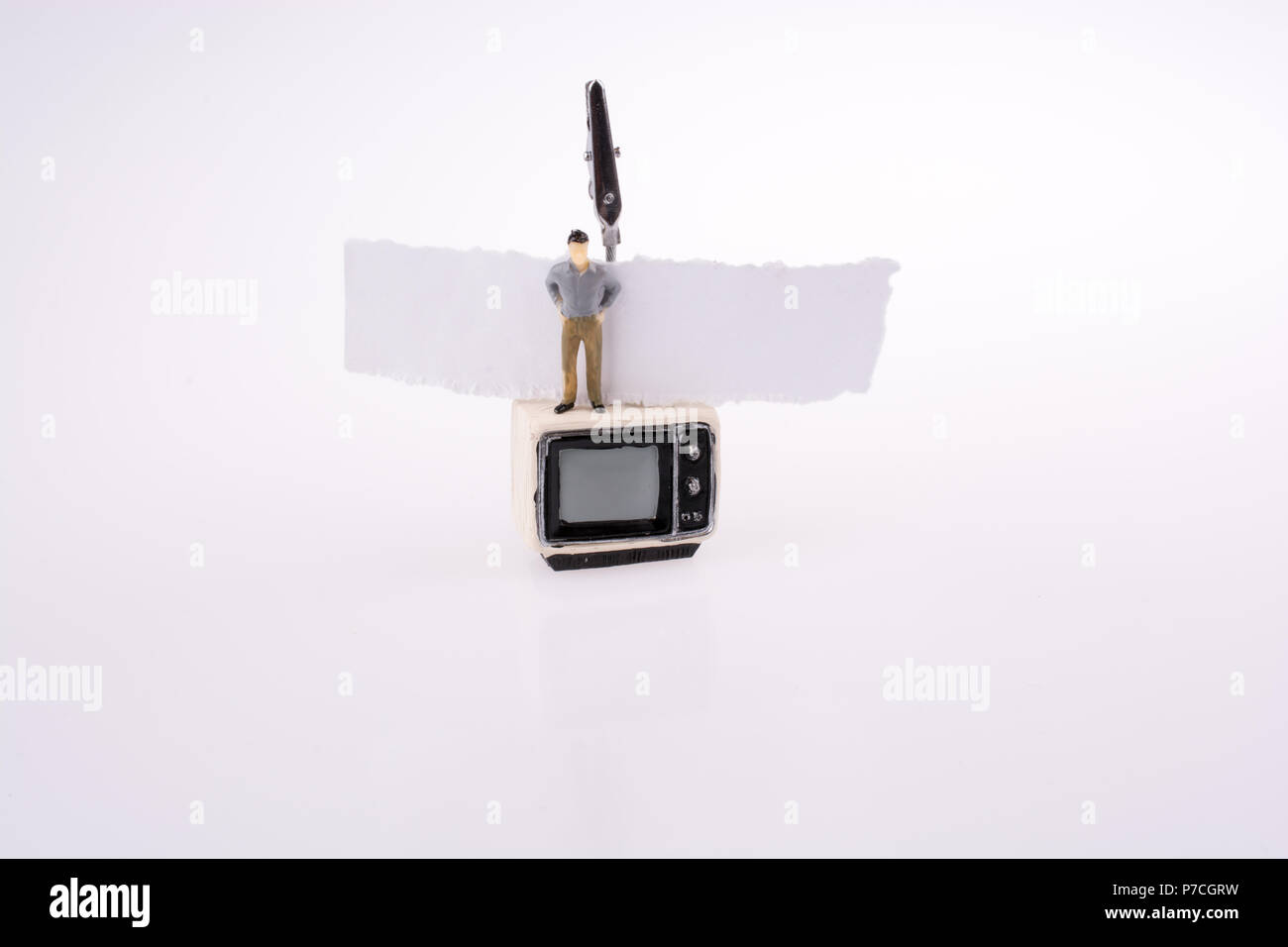 Man standing on the top of a retro styled television set with a piece ...