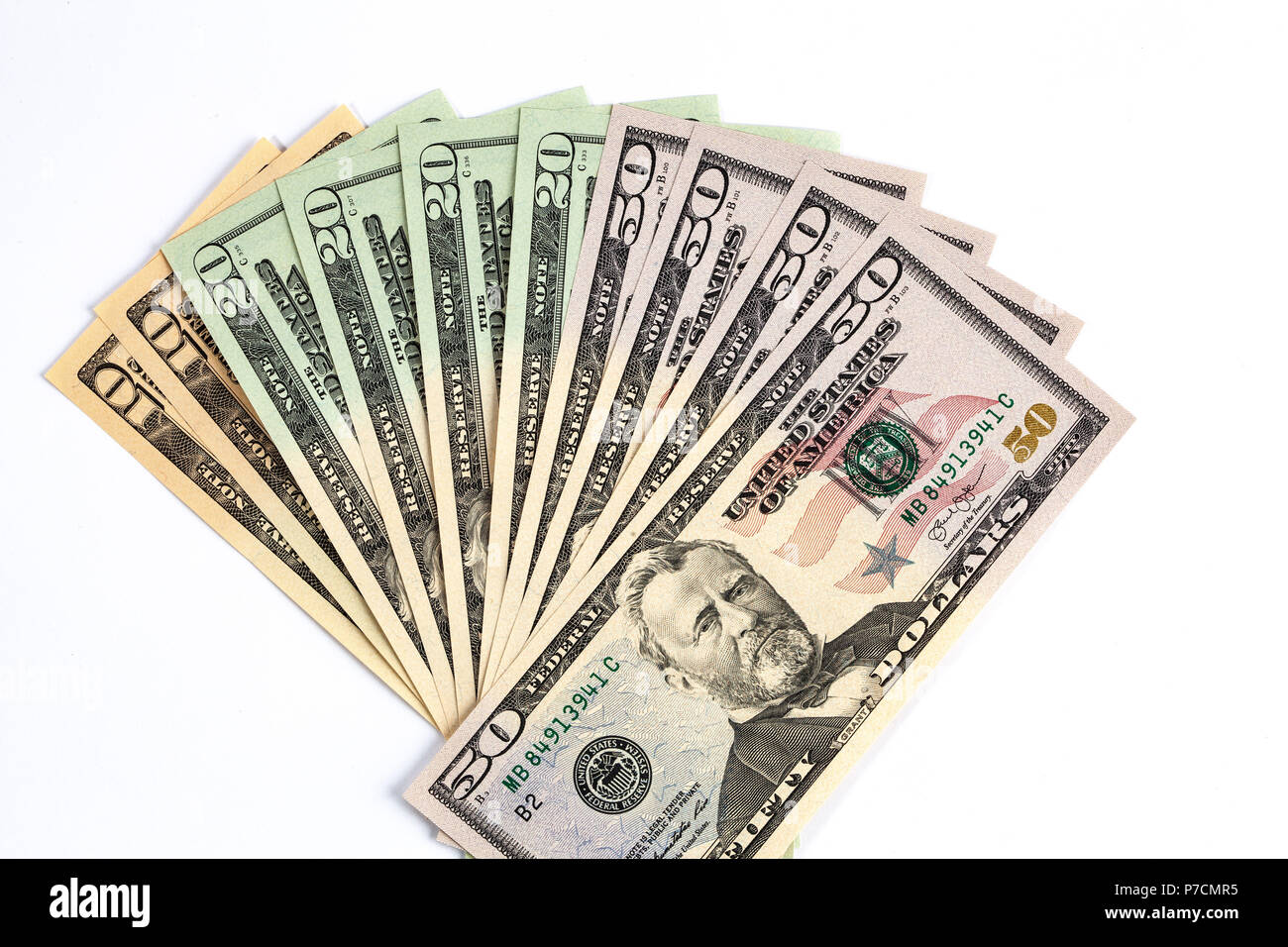 United States dollars arranged in fan shape on white background. 50, 20 ...