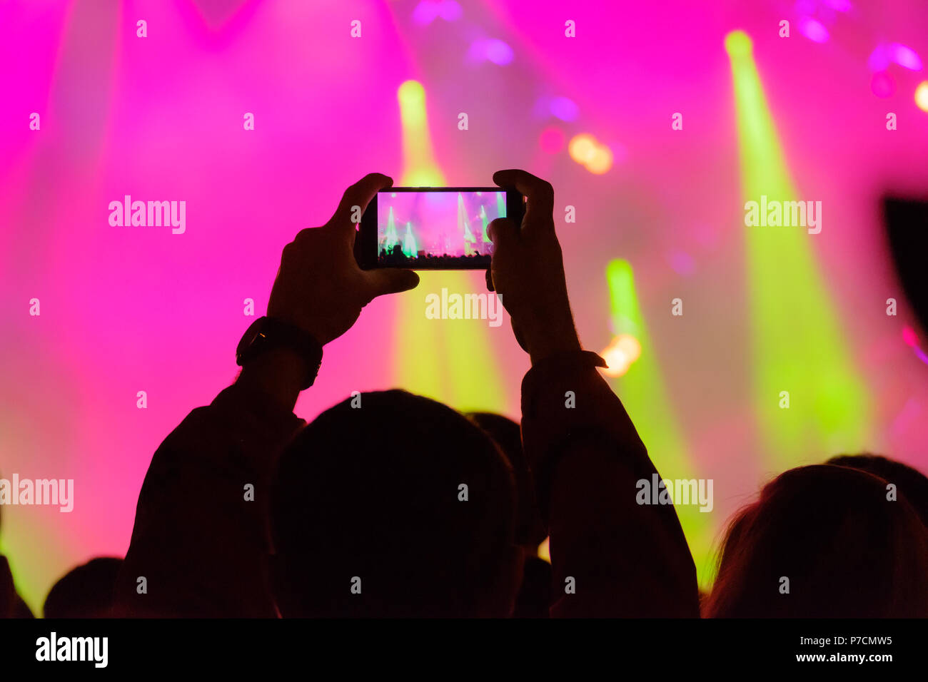Concert visitor shoots video on a smartphone Stock Photo - Alamy