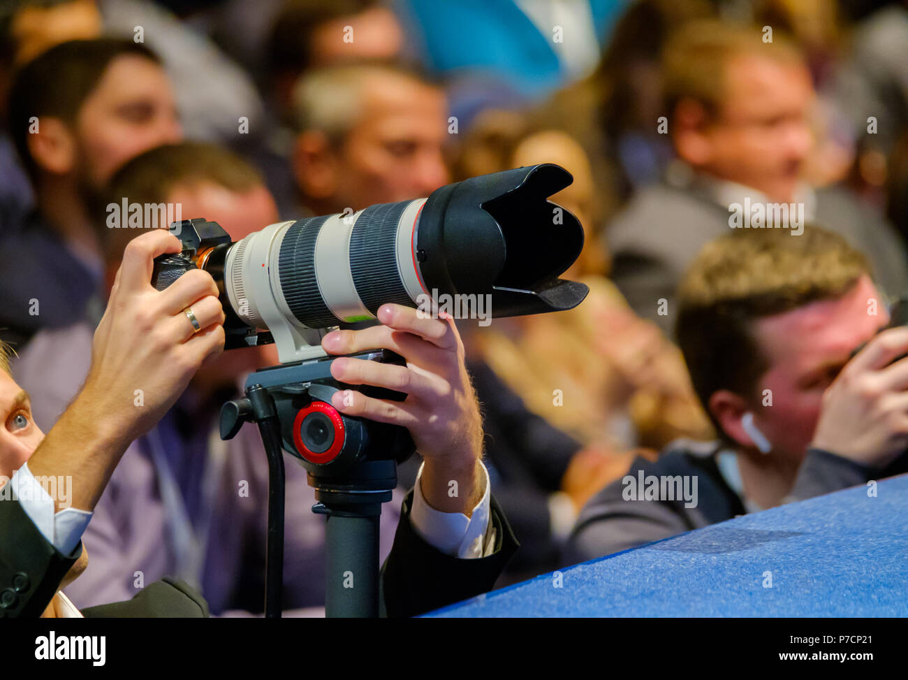 Professional photographer works at business conference Stock Photo - Alamy