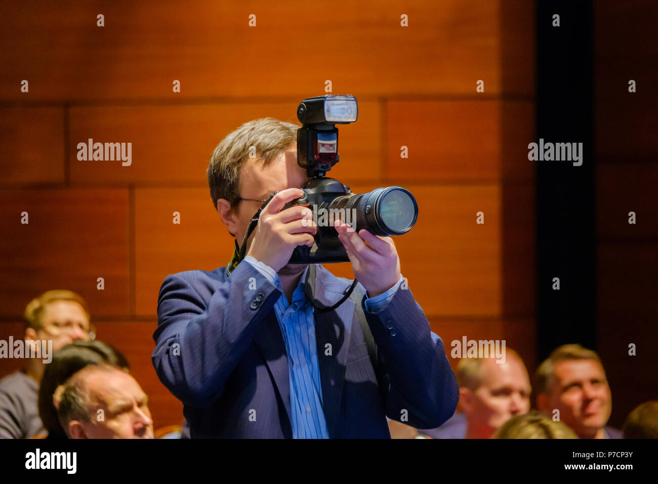 Professional photographer works at business conference Stock Photo - Alamy