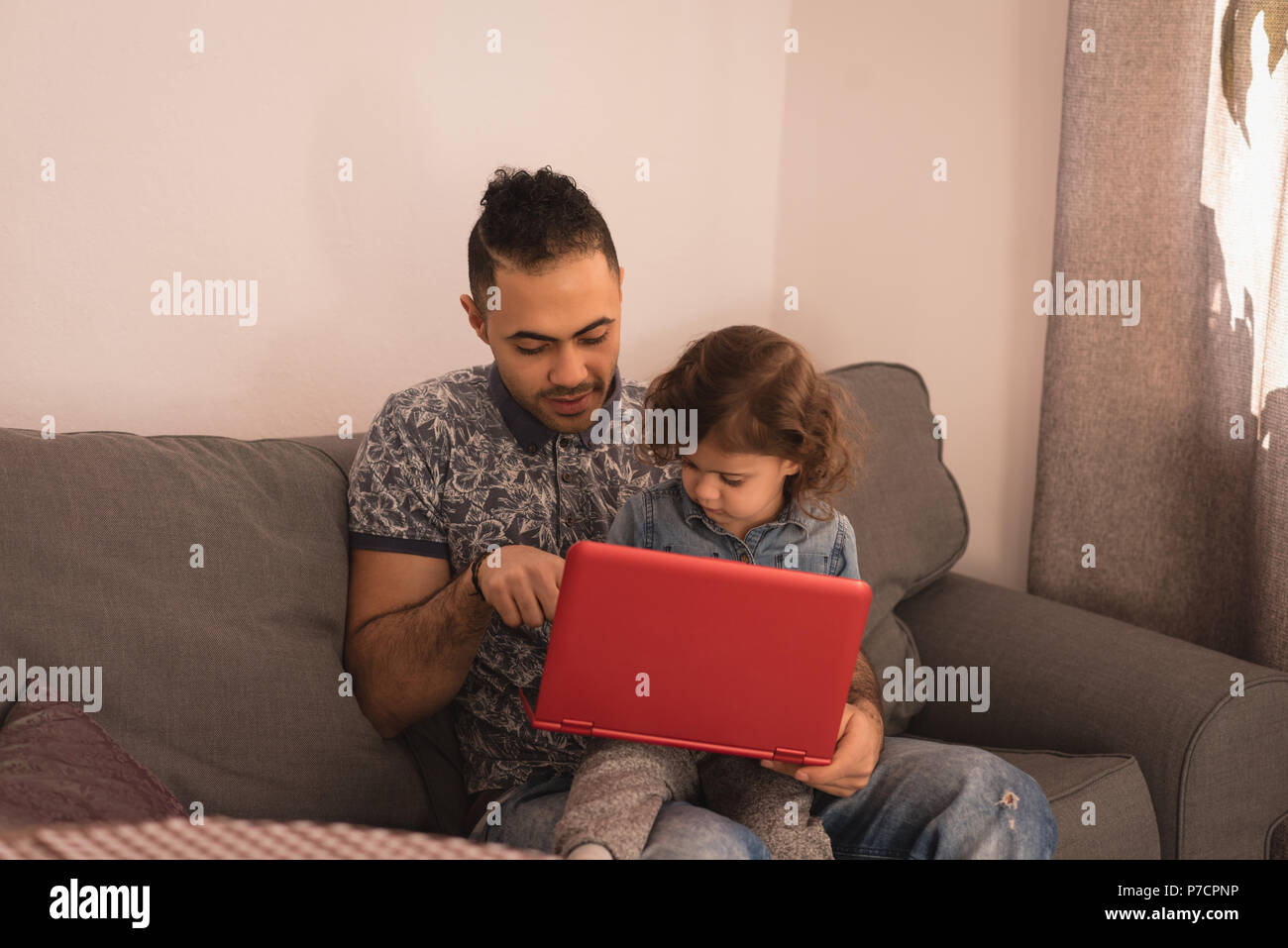 Father and daughter using laptop in living room Stock Photo - Alamy