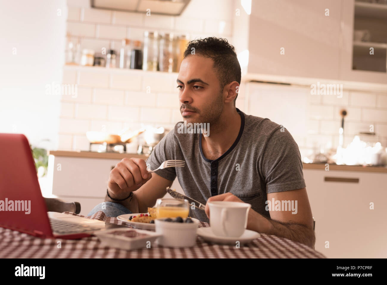 Man having breakfast in kitchen Stock Photo - Alamy