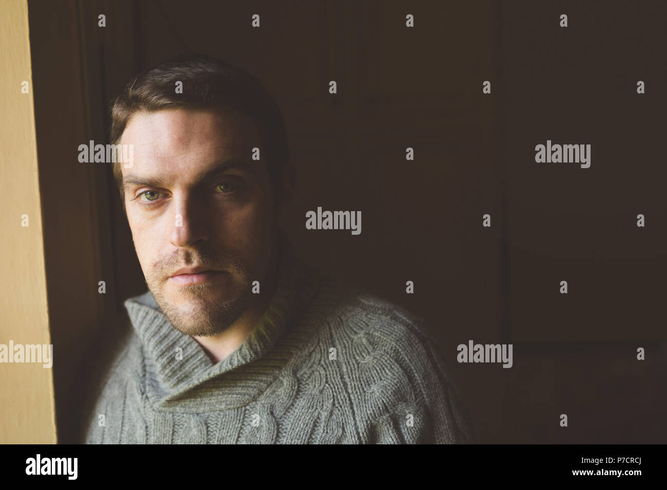 Man standing near window at home Stock Photo - Alamy