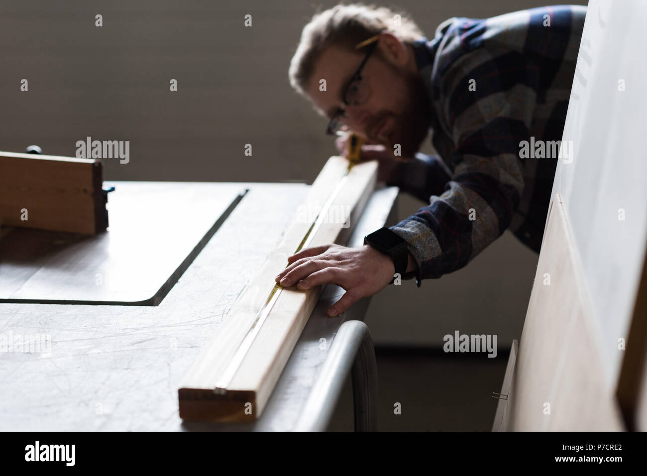Male carpenter taking measurement of wood Stock Photo - Alamy