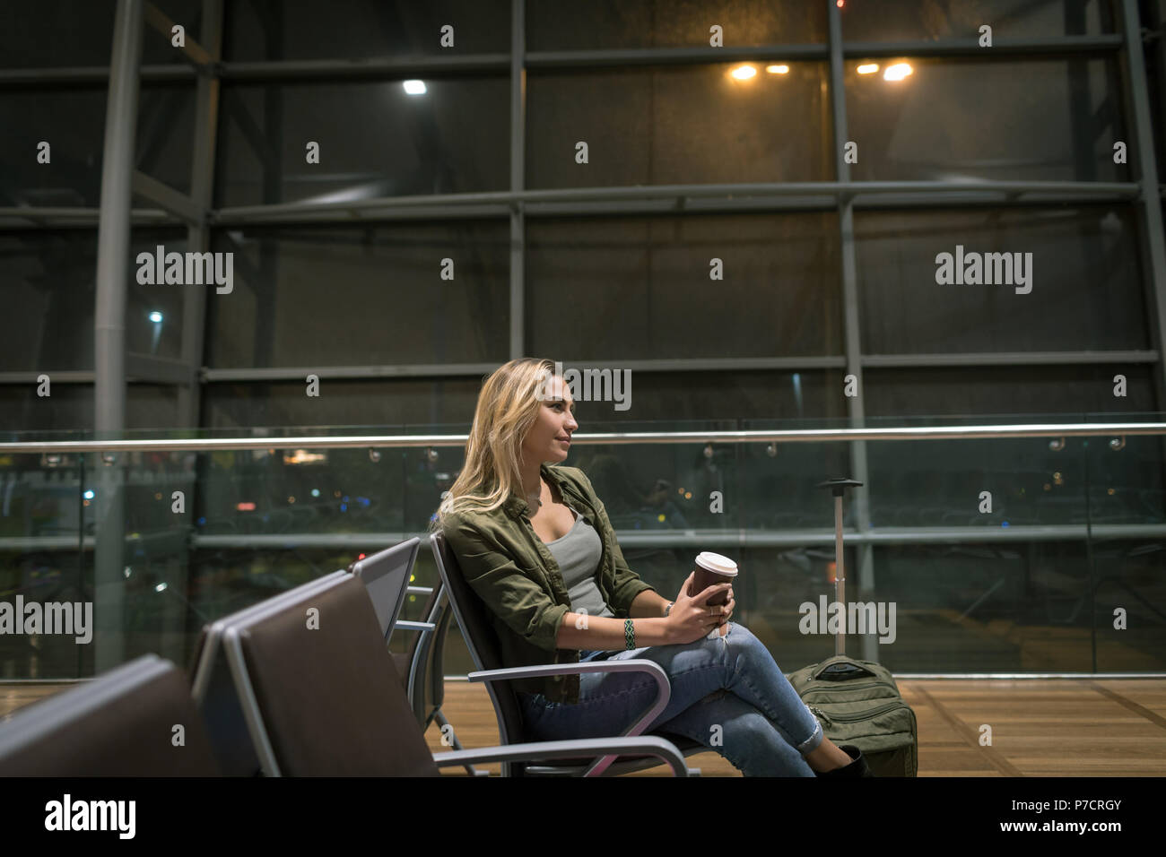 Woman having coffee in waiting area Stock Photo - Alamy