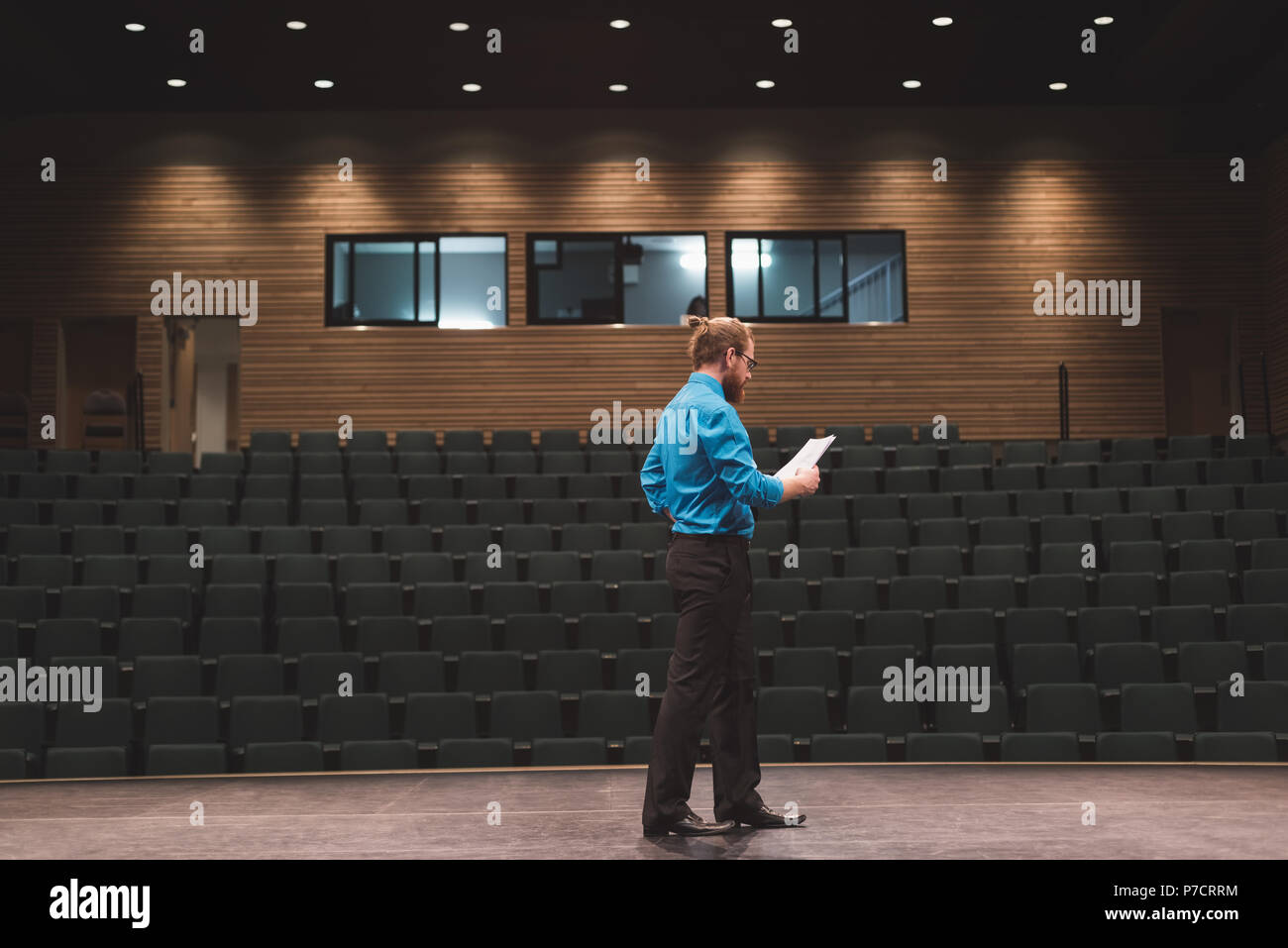 Male actor reading script on stage Stock Photo - Alamy