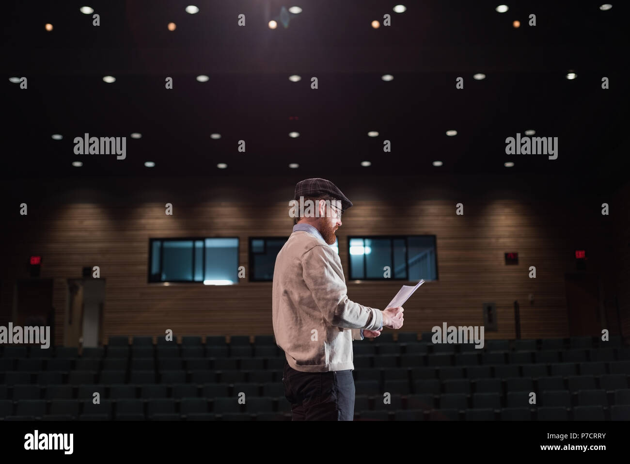 Male actor reading script on stage Stock Photo - Alamy
