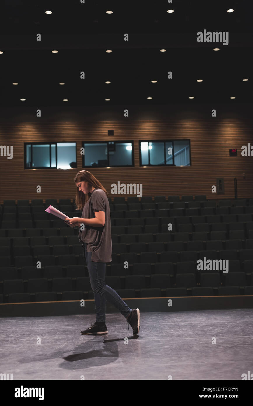 Female actress reading script on stage Stock Photo - Alamy