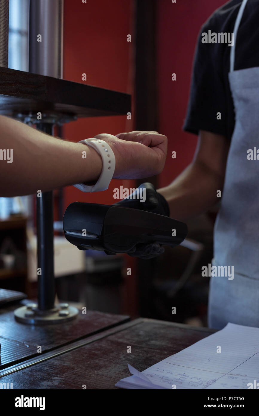 Customer making payment through smartwatch Stock Photo - Alamy