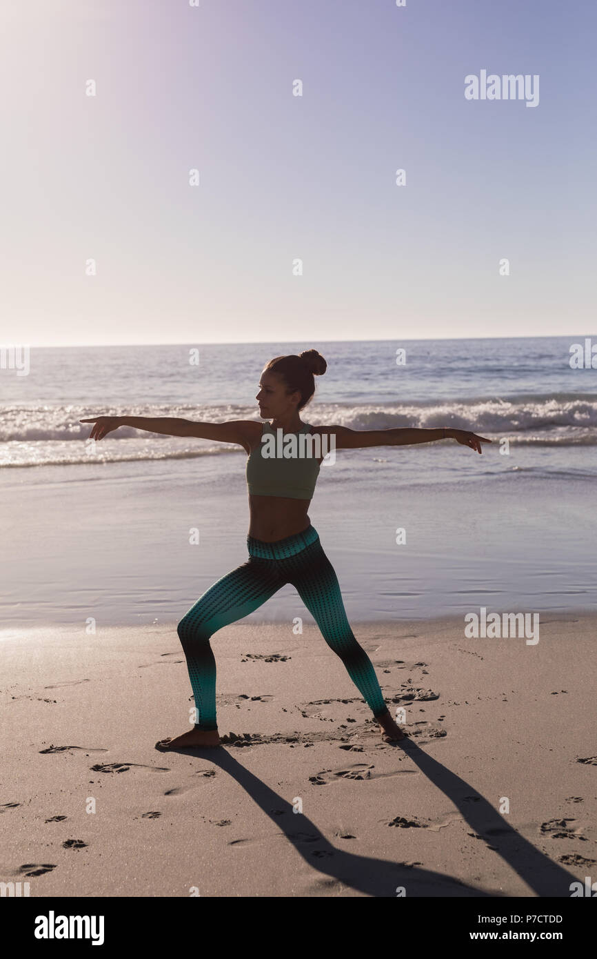 Fit woman performing stretching exercise in the beach Stock Photo - Alamy