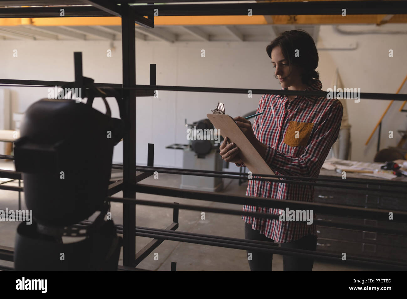Female welder writing on a clipboard Stock Photo - Alamy