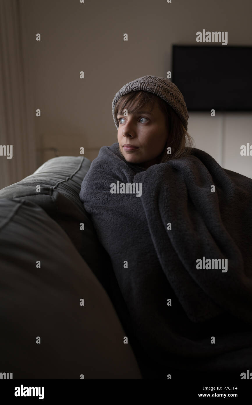 Woman wrapped up in blanket at home Stock Photo - Alamy