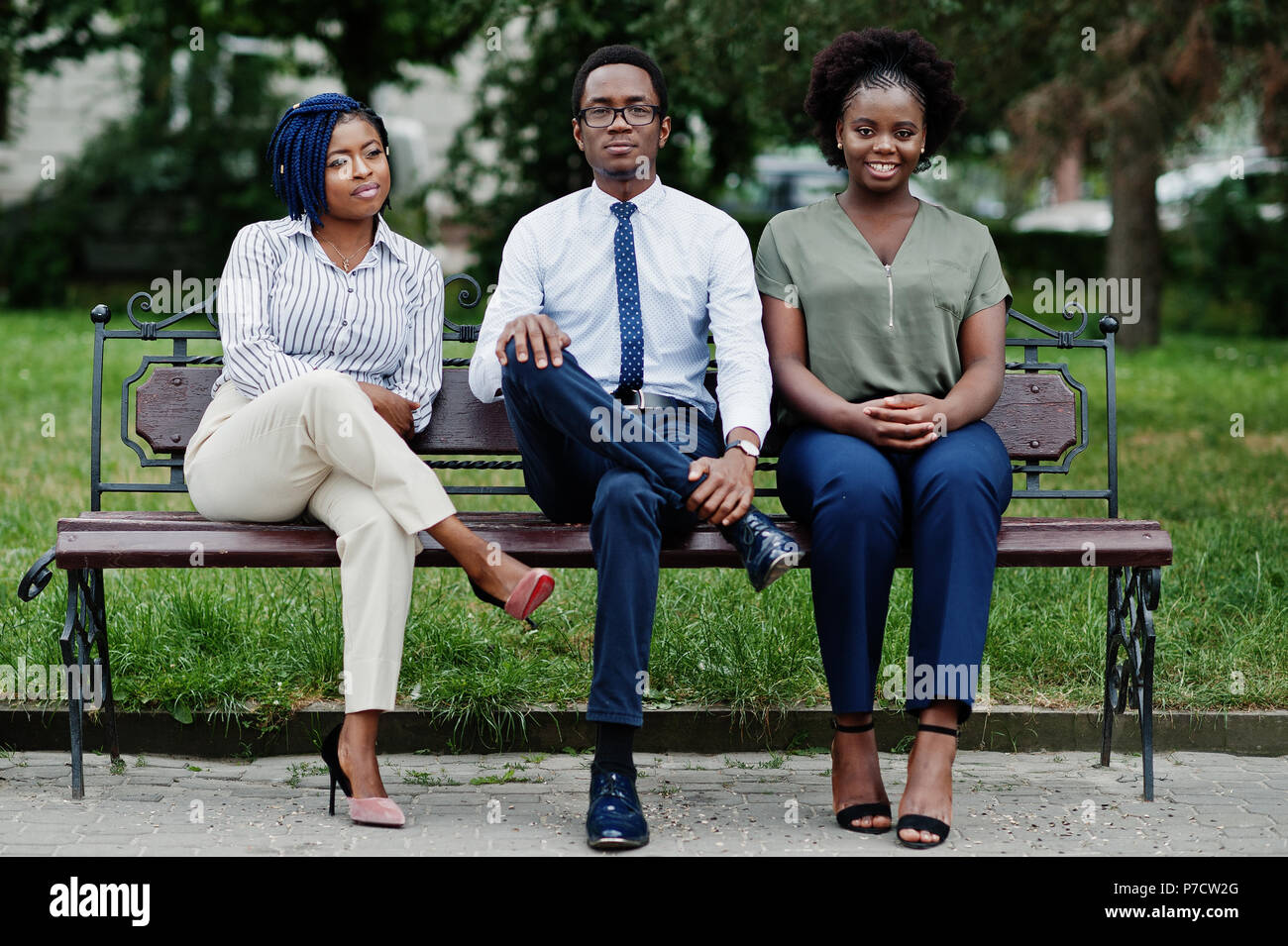 Group of three african american people posed at street of city sitting ...