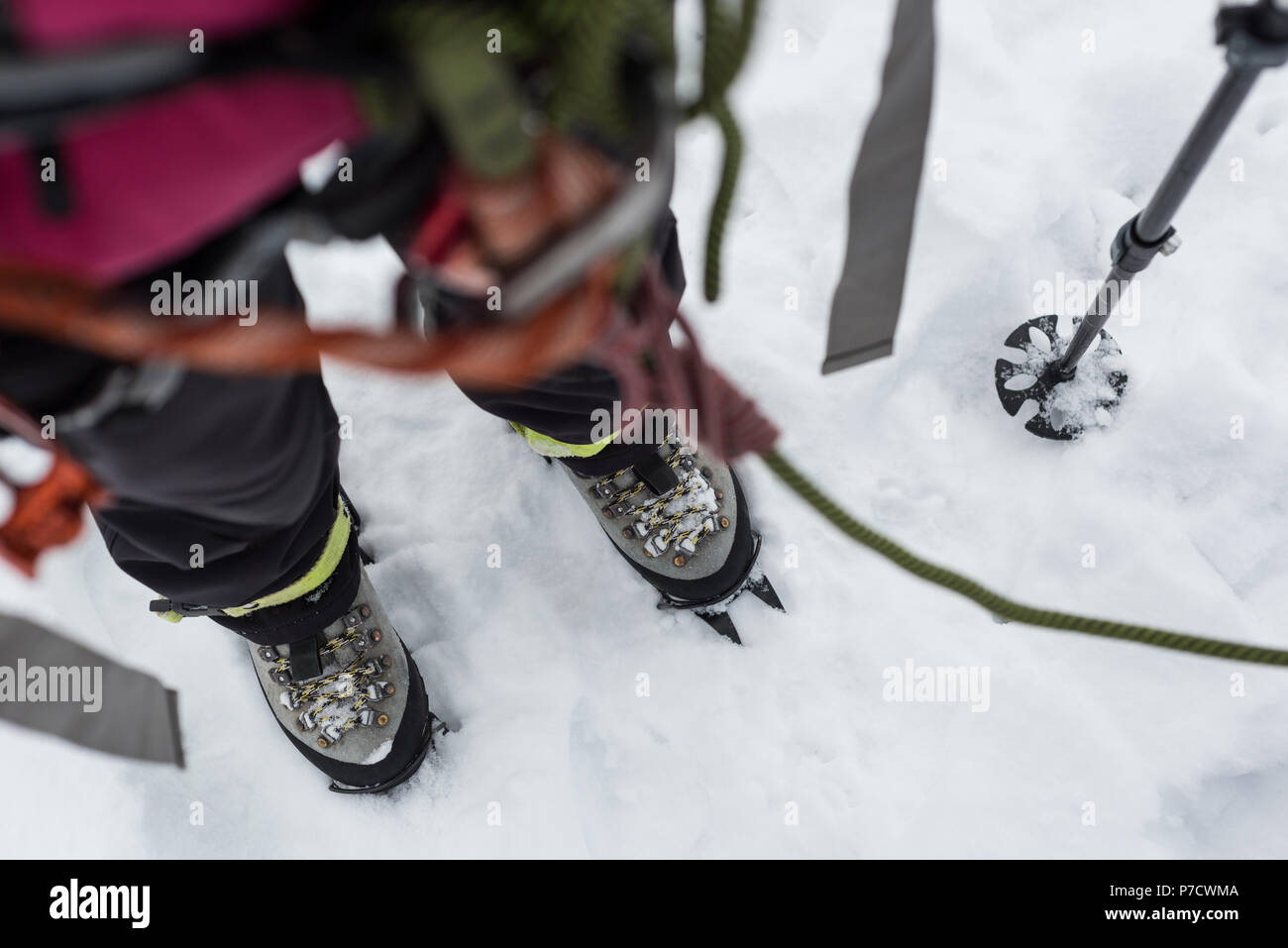 Female mountaineer standing with harness and rope in snowy region Stock ...