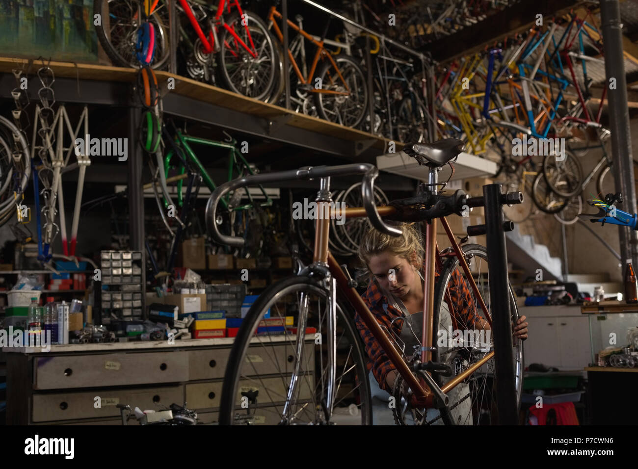 Female mechanic examining a bicycle Stock Photo - Alamy