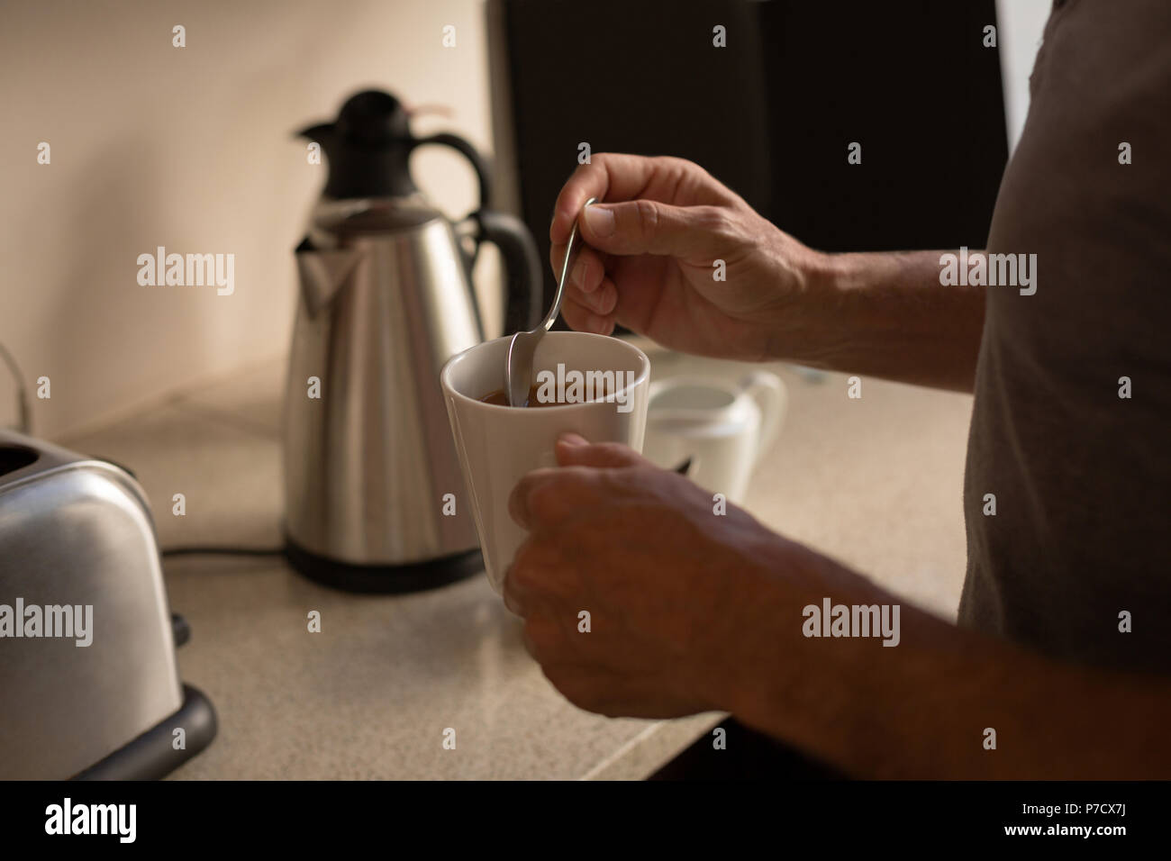 Senior man stirring coffee in kitchen at home Stock Photo - Alamy