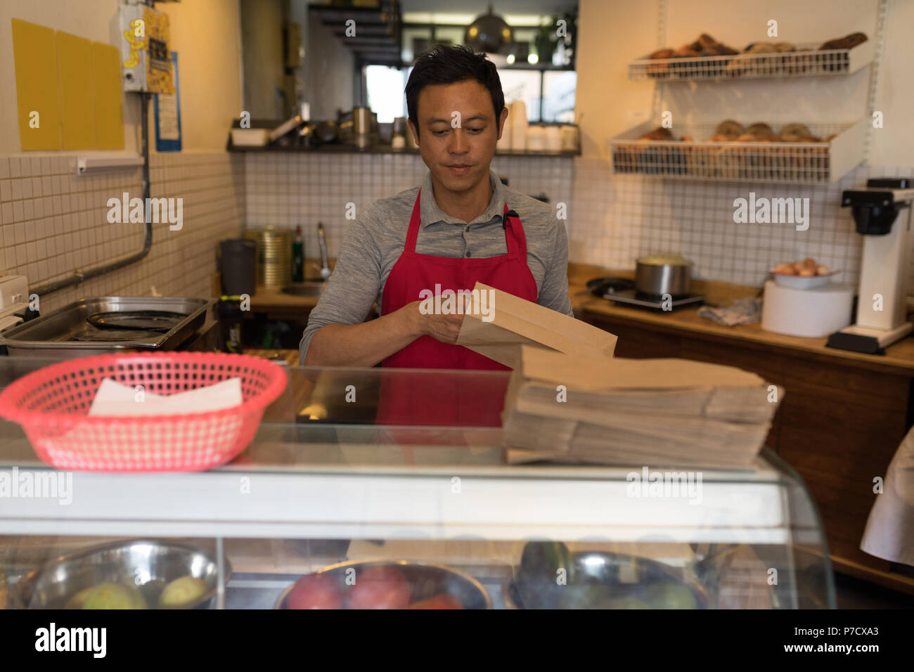 Staff packing food in paper bag Stock Photo - Alamy