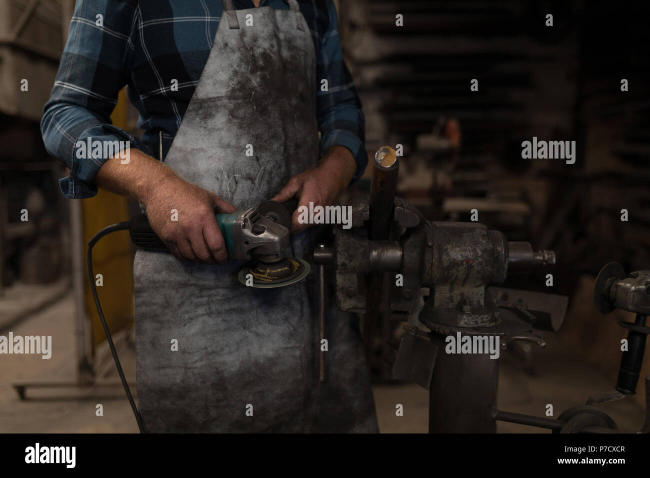 Blacksmith grinding a metal rod with grinder machine Stock Photo - Alamy