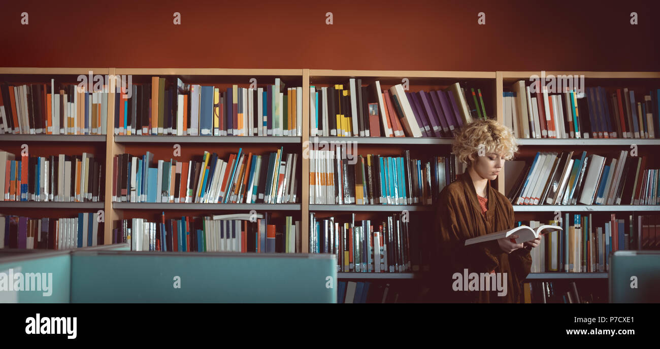 Woman reading a book in library Stock Photo - Alamy