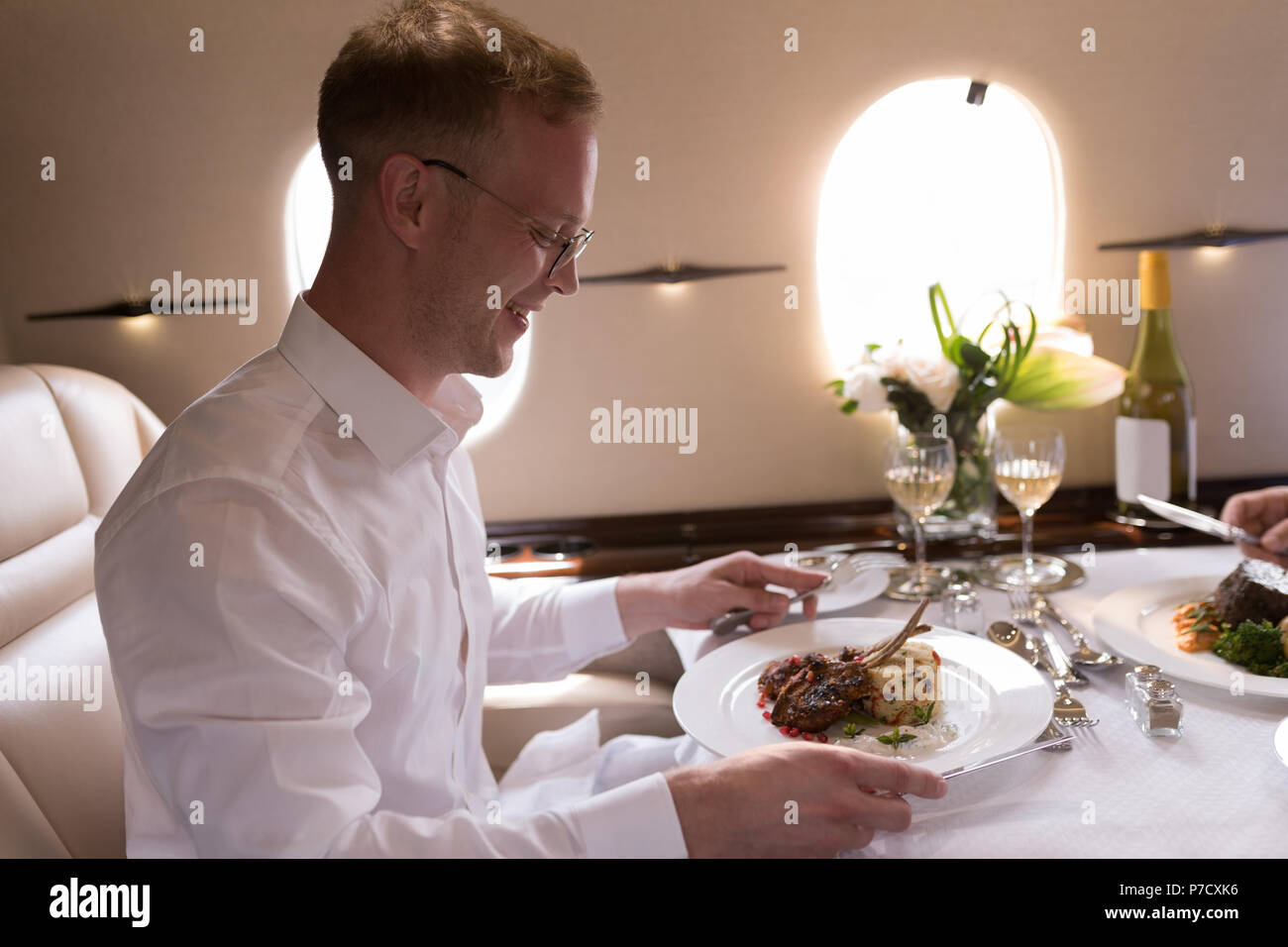 Businessman having meal while traveling in private jet Stock Photo - Alamy