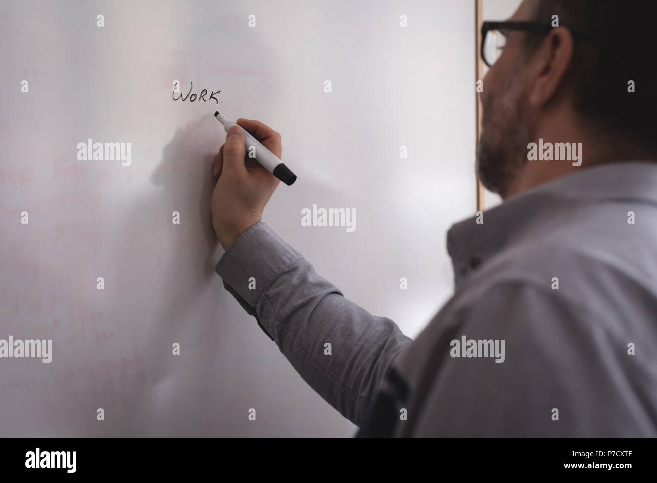 Male executive writing on whiteboard Stock Photo - Alamy