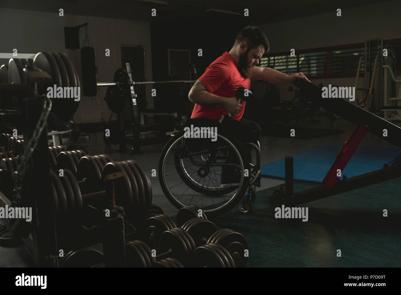 Handicapped man on wheelchair working out with dumbbell Stock Photo - Alamy
