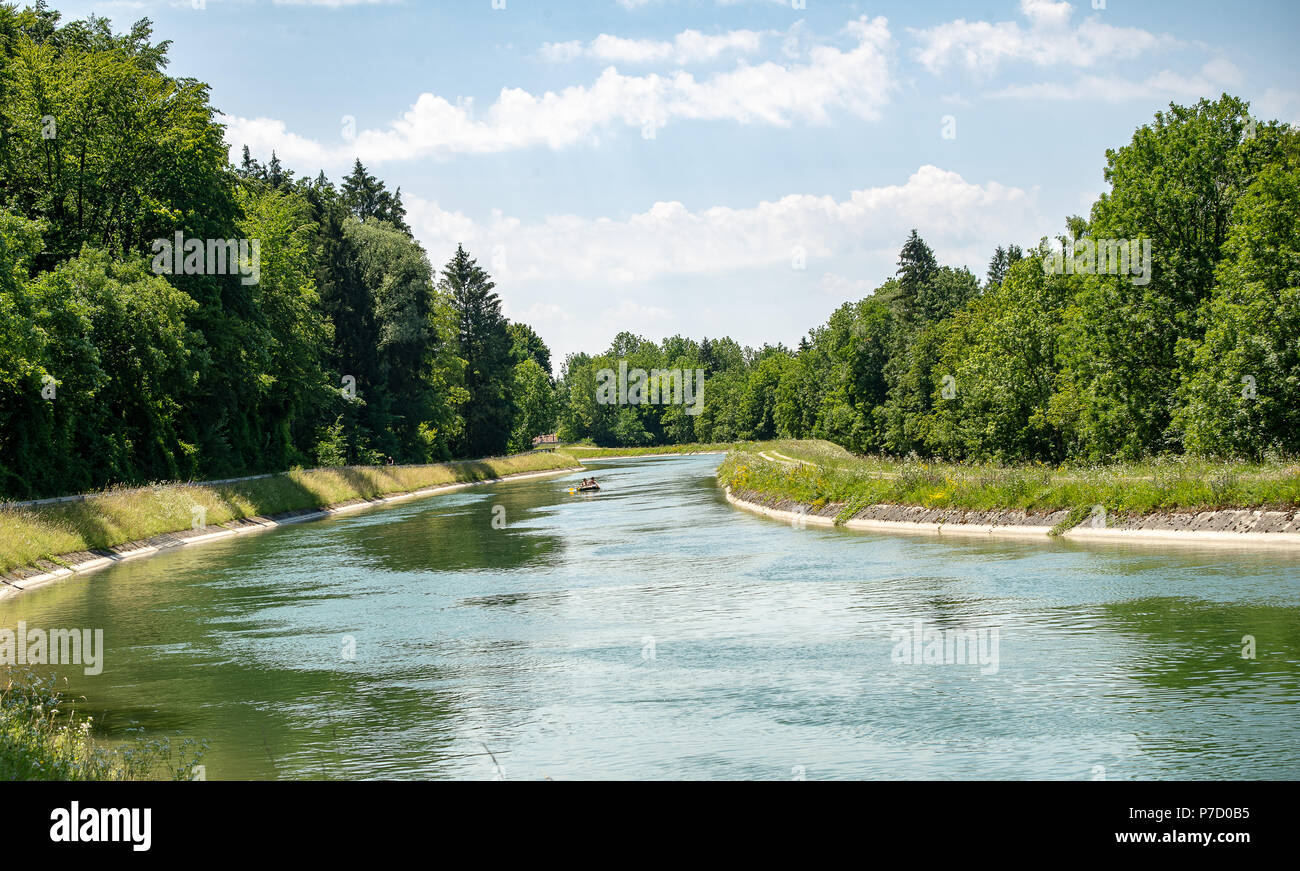 Two people paddle on an inflatable rubberboat on a side channel of the ...