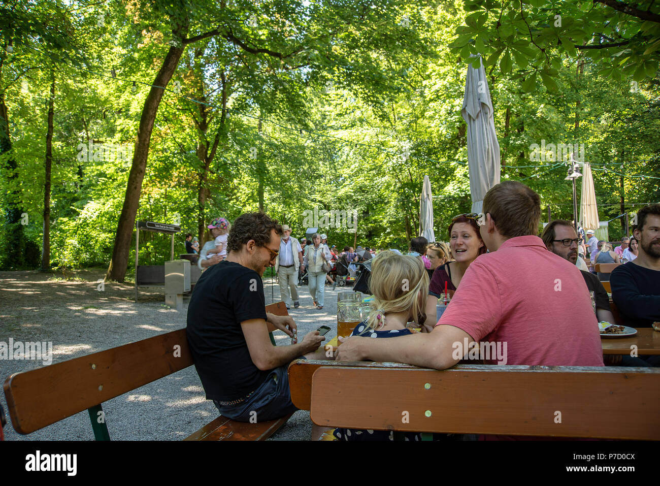 People have lunch under the shade of trees in a biergarten Stock Photo ...
