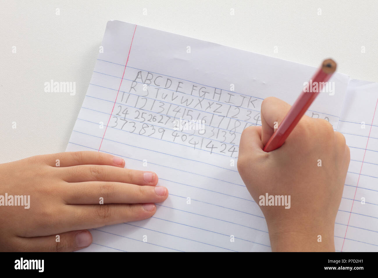 Children's hands holding pencil and doing homework in isolated white ...