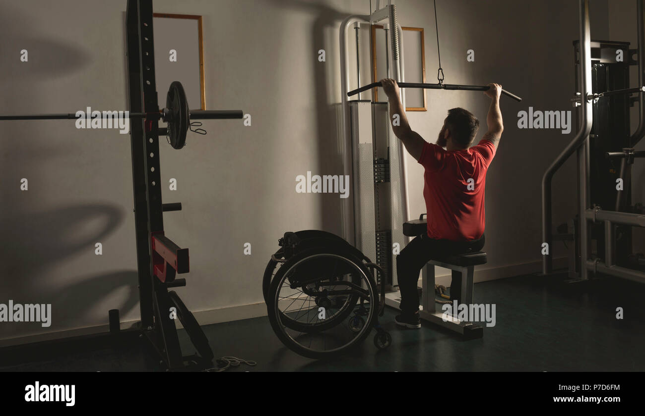 Handicapped man working out lat pulldown training Stock Photo - Alamy