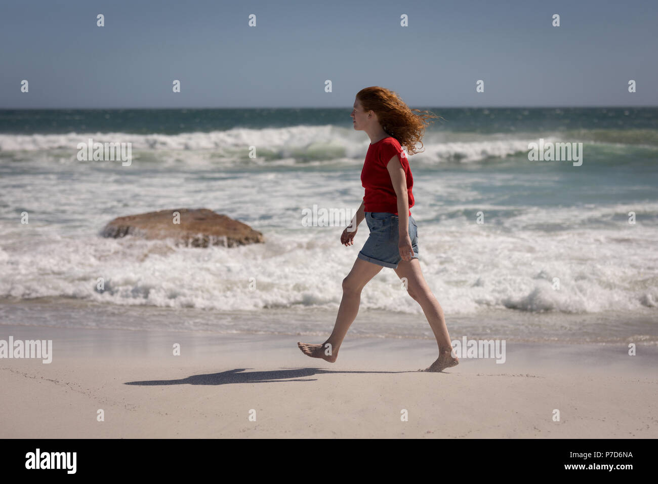 Woman walking on sand at beach Stock Photo - Alamy