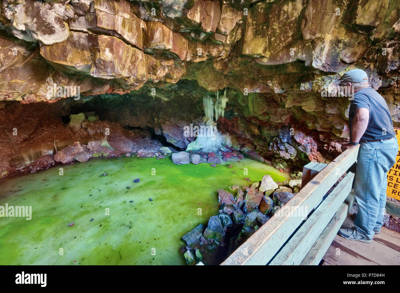 Tourist at frozen pool inside Ice Caves in summer, inside lava field at ...