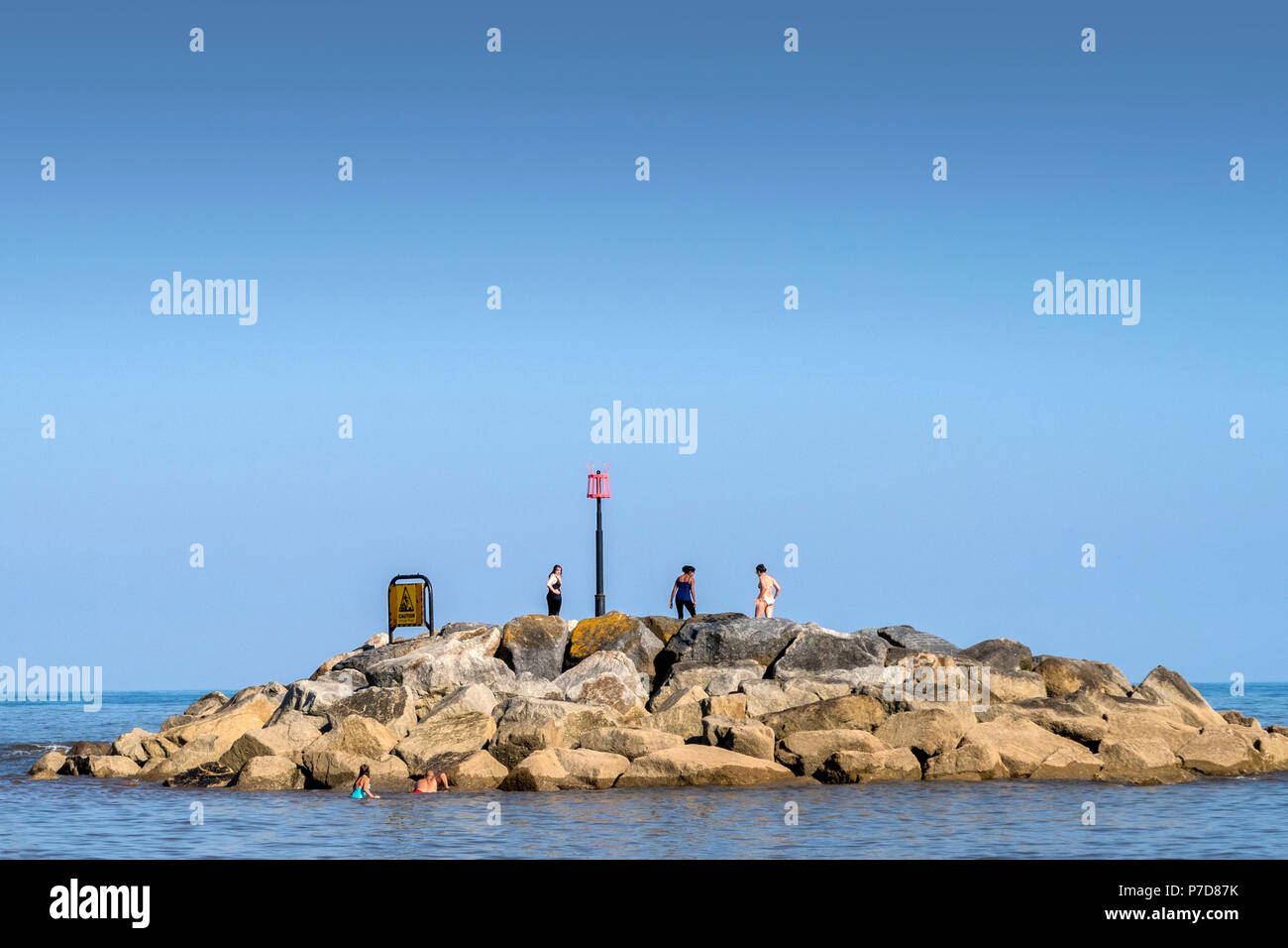 People climbing onto rock groynes at Sidmouth, despite warning signs ...