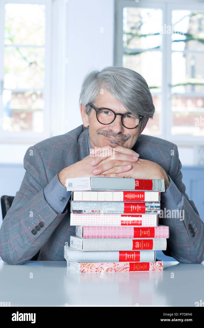 Man leaning on a book pile Stock Photo - Alamy