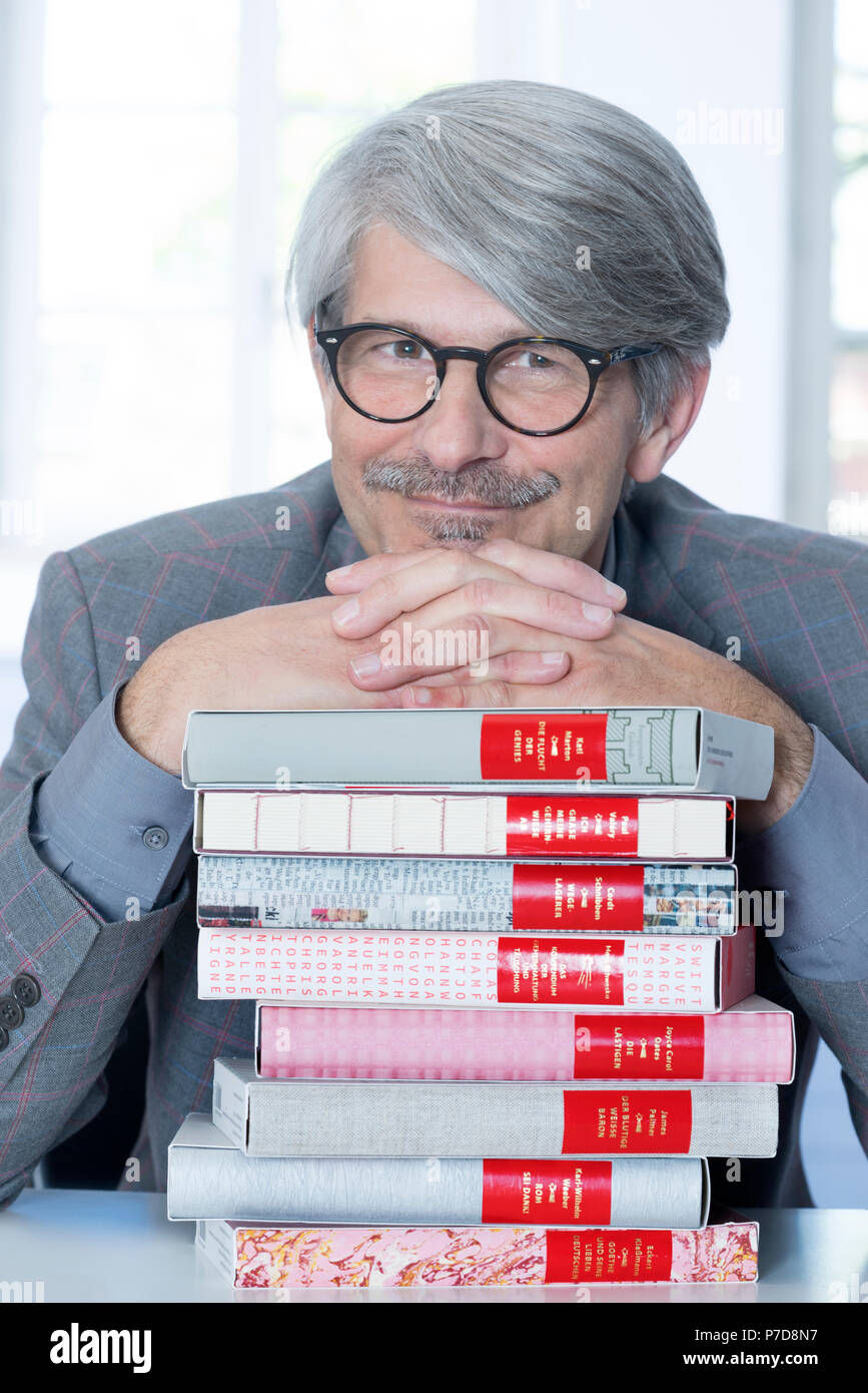 Man leaning on a book pile Stock Photo - Alamy