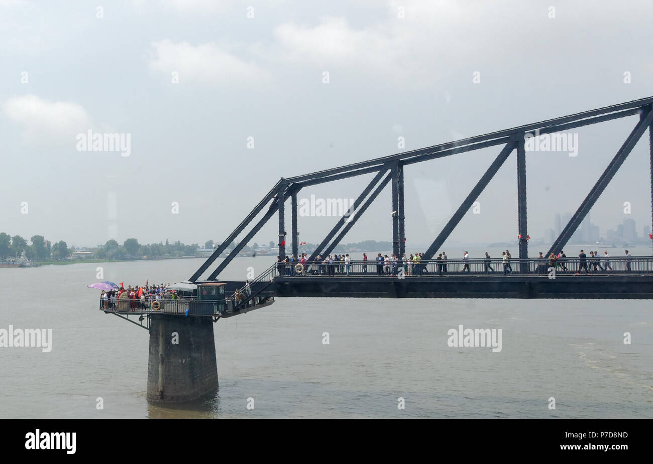 Tourists and locals line the Broken Bridge on the Yalu River, a ...