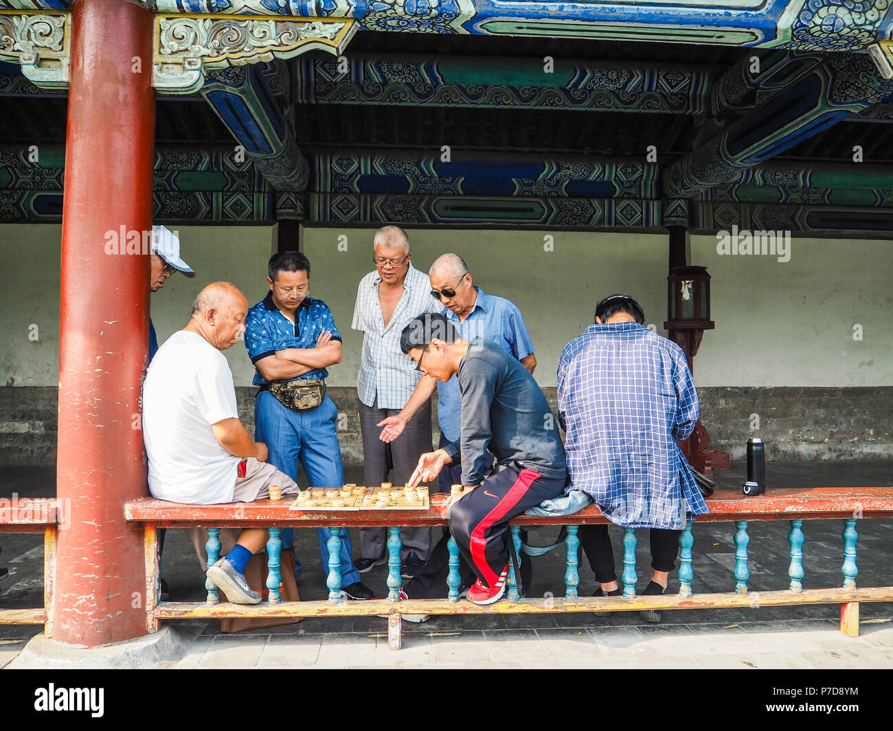 Group of men playing traditional Chinese chess in the long corridor of ...