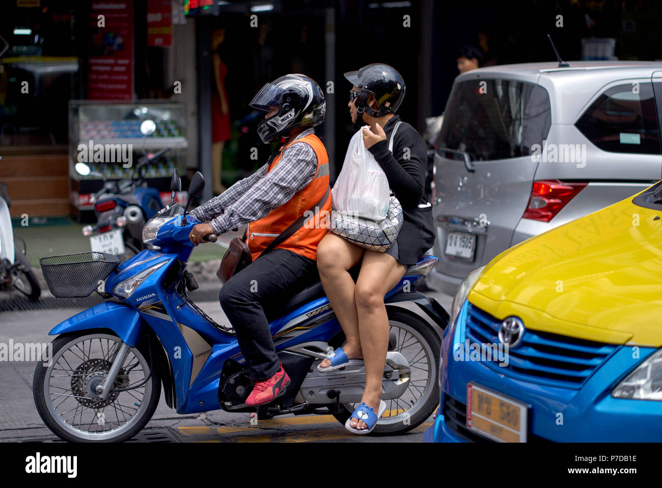 Thailand motorcycle taxi and female passenger in traffic. Southeast ...