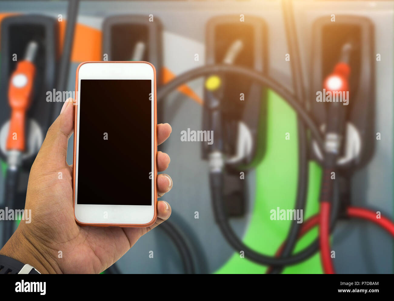 Male hand hold white smartphone and checking fuel price on gasoline ...