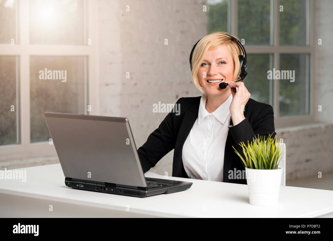 Call center operator, blonde woman dressed in black jacket and white ...