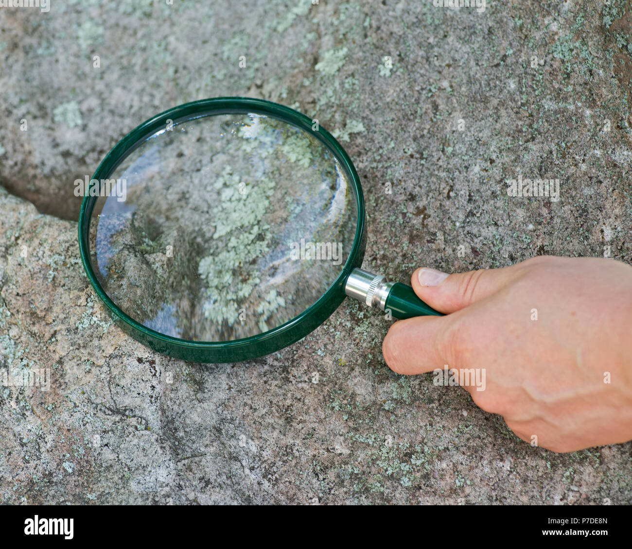 Woman examining rock formation through a magnifying glass Stock Photo ...