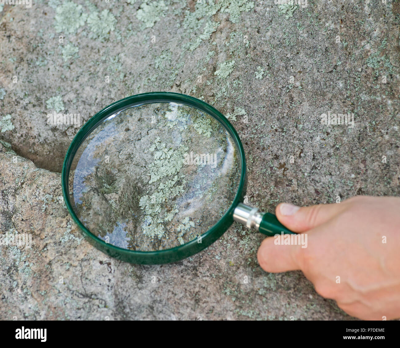 Woman examining rock formation through a magnifying glass Stock Photo ...
