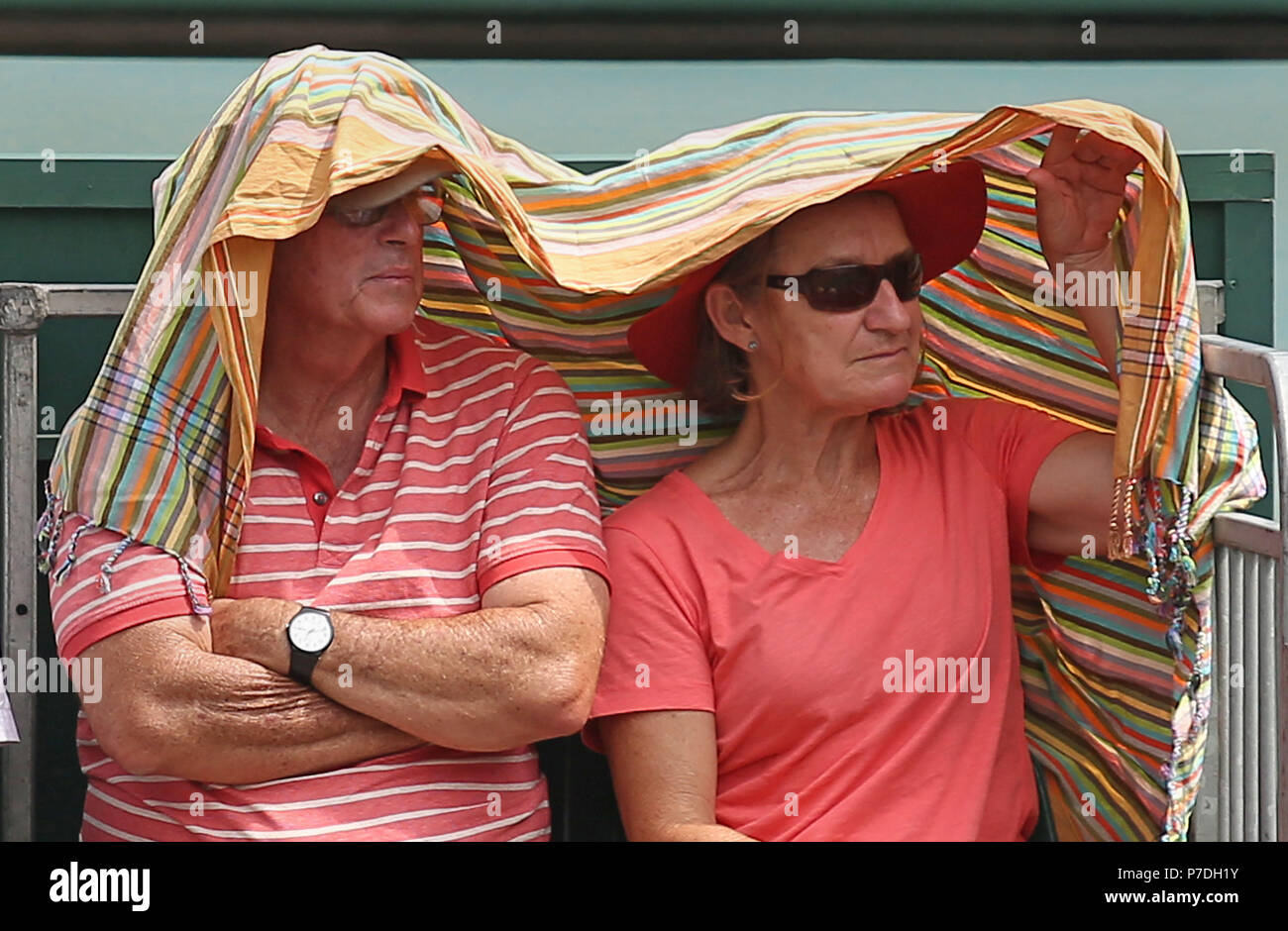 Spectators on court 17 shield themselves from the sun on day four of ...