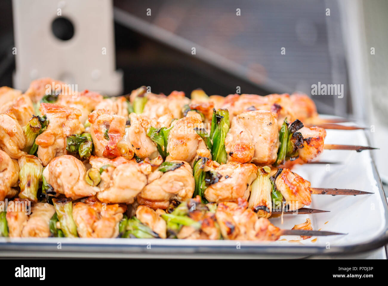 Step by step. Chicken yakitori on a white metal serving tray next to ...