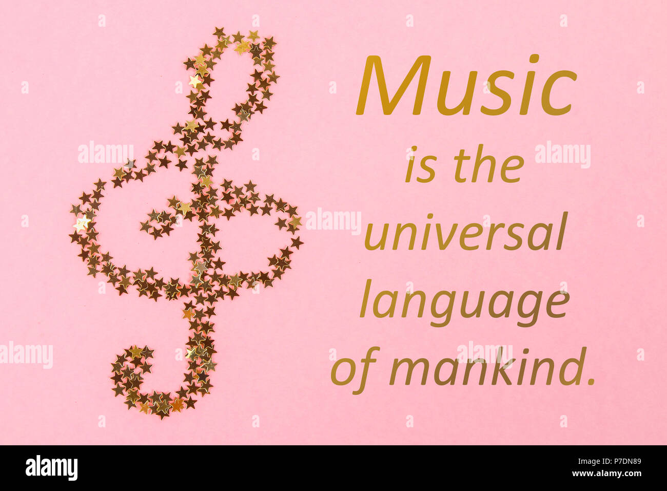 Musical notes of starry golden confetti lying on a pink pastel ...