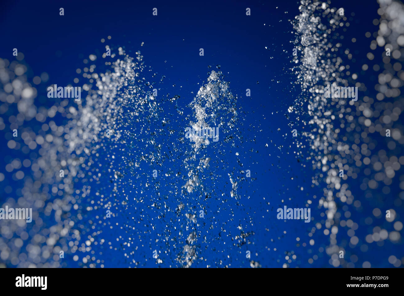 Splash water flow on blue background Stock Photo - Alamy