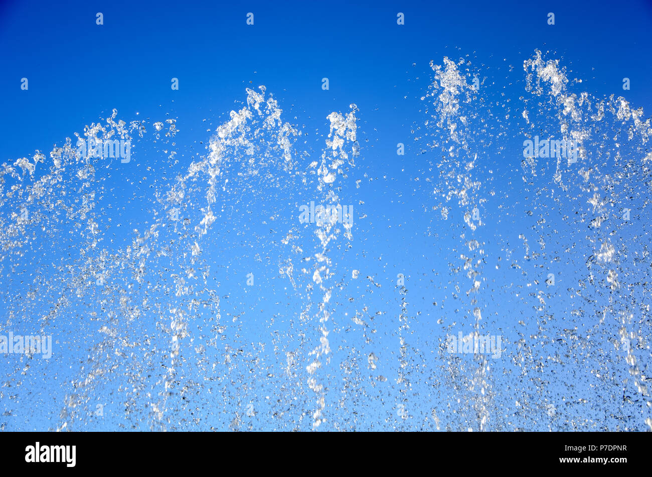 Splash water flow on blue background Stock Photo - Alamy
