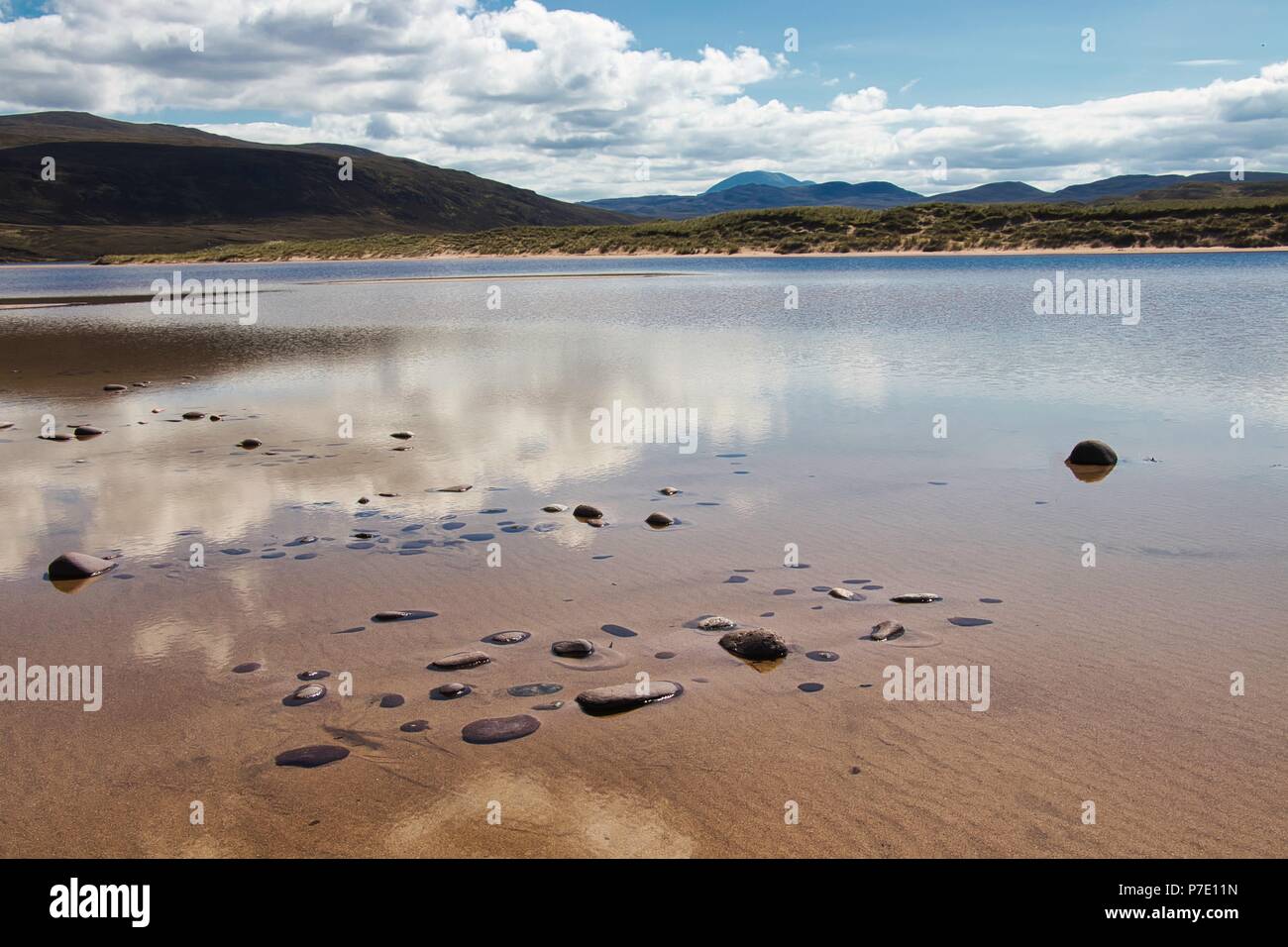 Clouds reflected on a shallow loch, near Kearvaig, Scottish Highlands ...