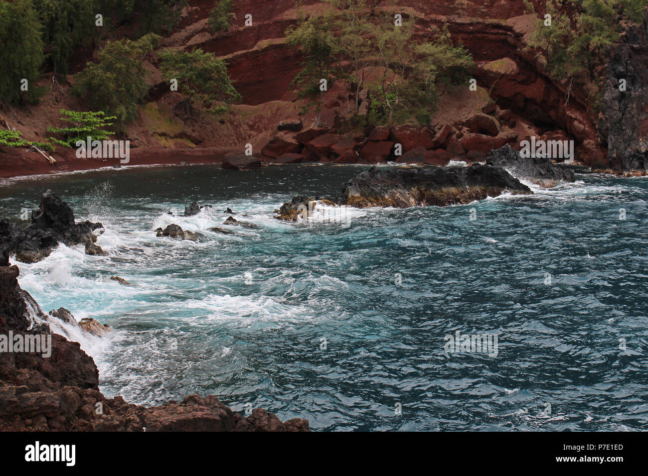 Towering, sheer, red cliff walls leading to a cove of the Red Sand ...
